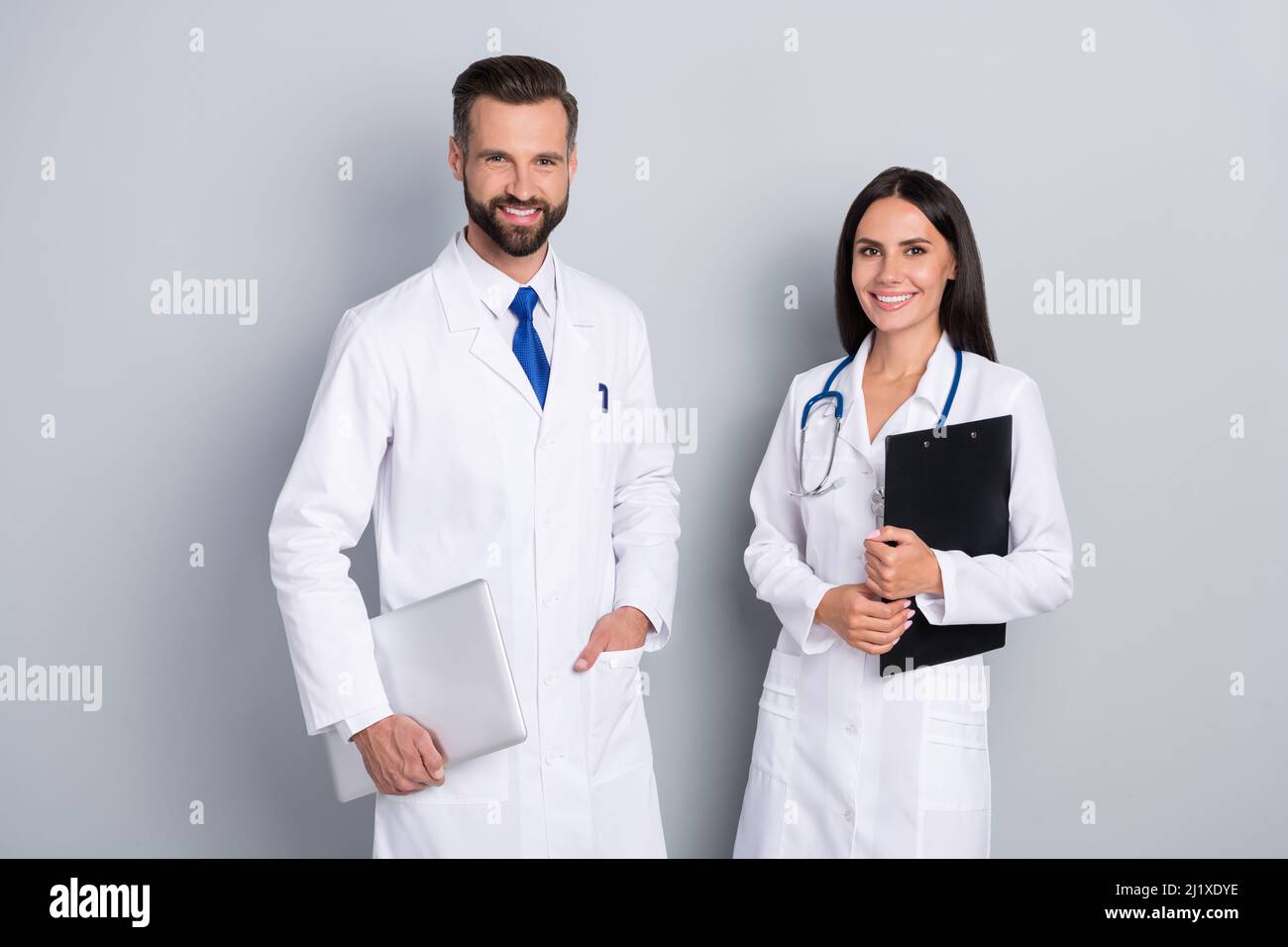Portrait of two attractive cheerful smart experienced doctors holding ...
