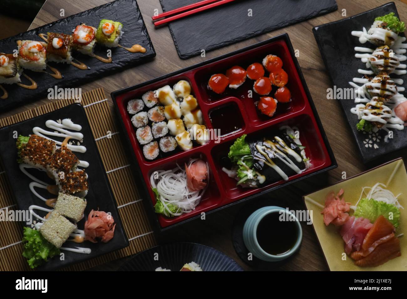 A top view of a sushi set and sushi rolls with soy sauce and side ...