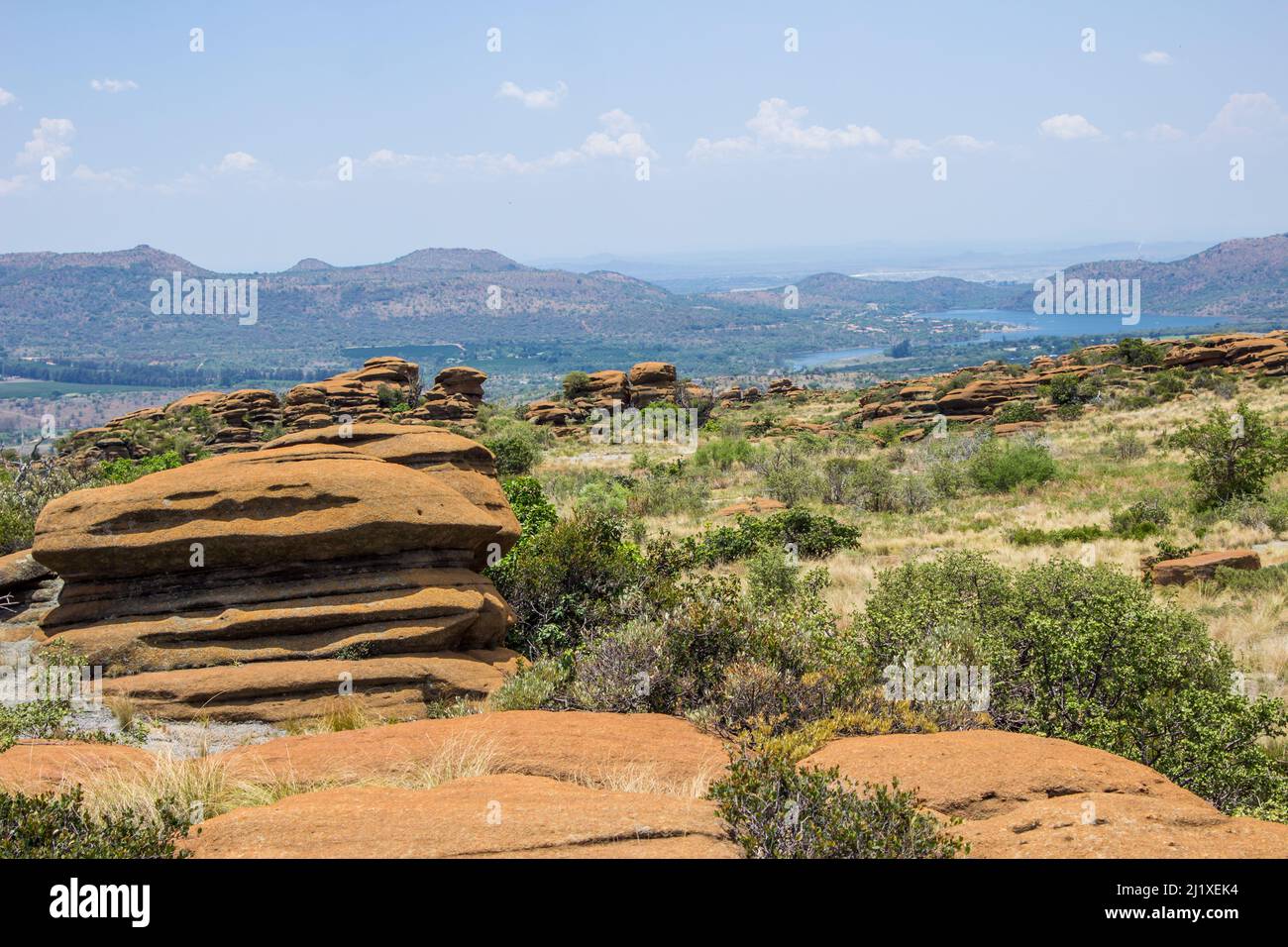 Weathered Quartzite boulders with Hartbeespoort dam and mountain ridges ...