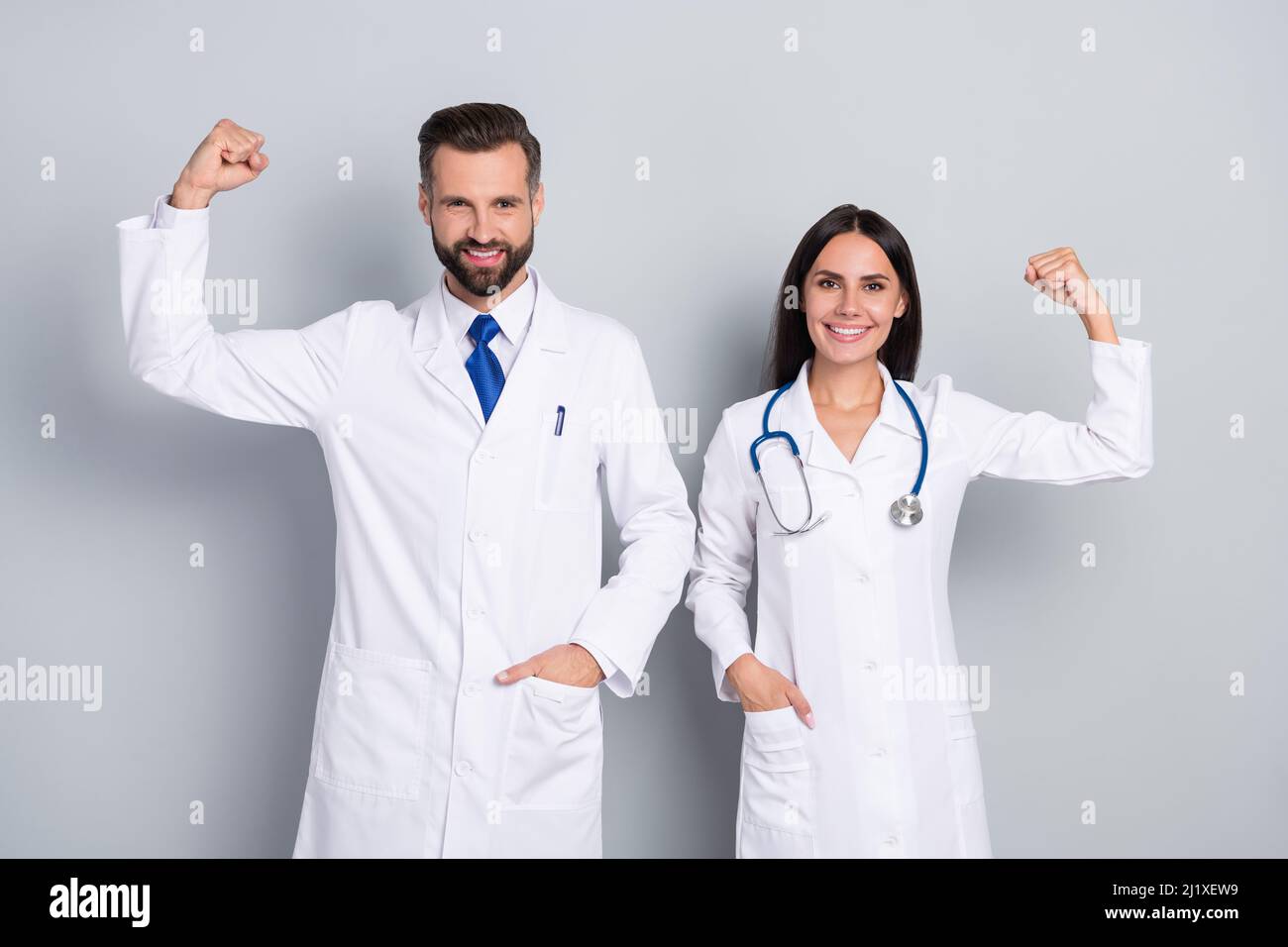 Portrait of two attractive successful cheerful medics demonstrating ...