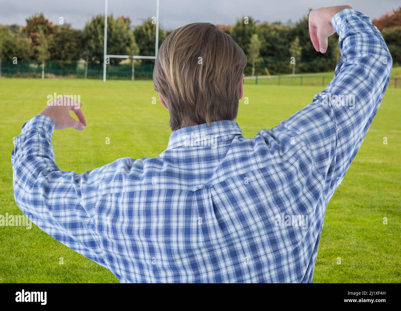Composite image of rear view of man holding an invisible object against ...