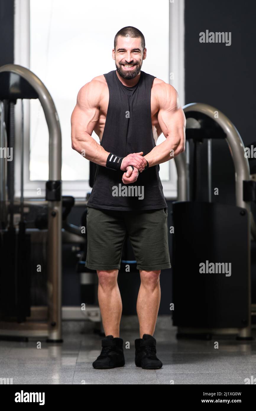 Handsome Young Man Standing Strong In The Gym And Flexing Muscles ...