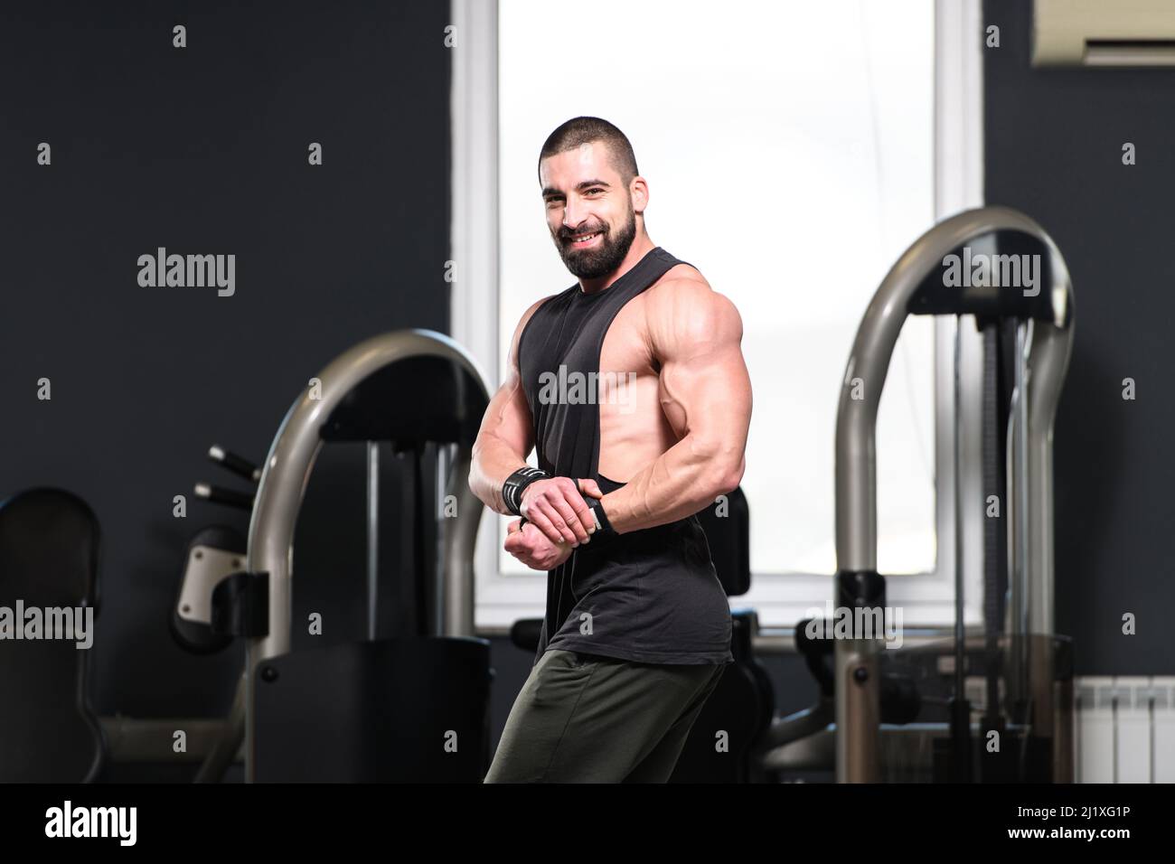 Young Man Standing Strong In The Gym And Flexing Muscles - Muscular ...