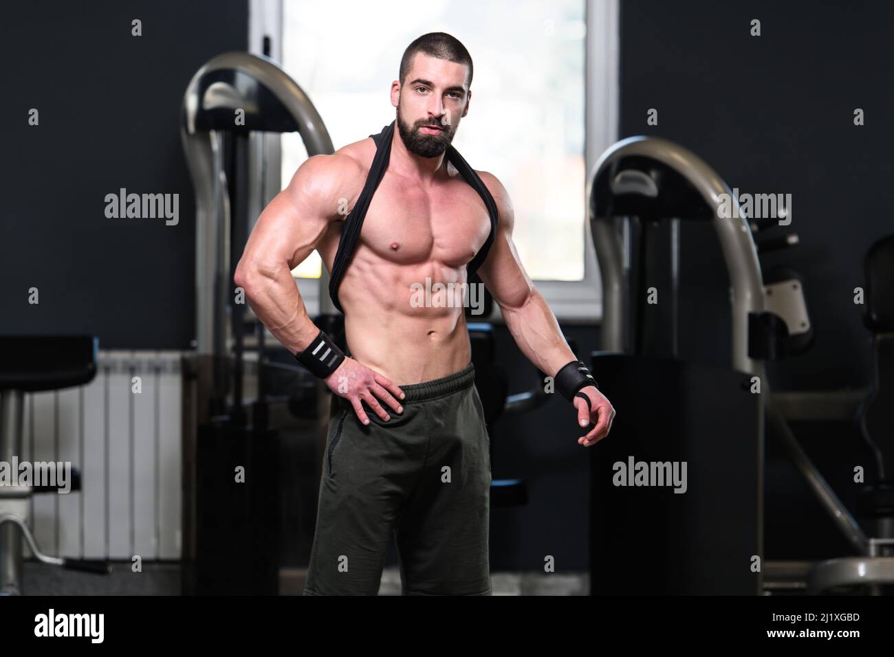 Young Man Standing Strong In The Gym And Flexing Muscles - Muscular ...