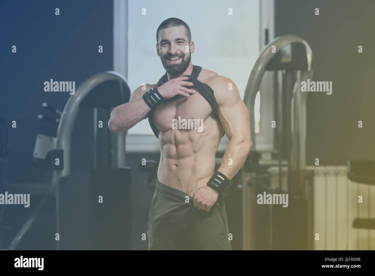Young Man Standing Strong In The Gym And Flexing Muscles - Muscular ...