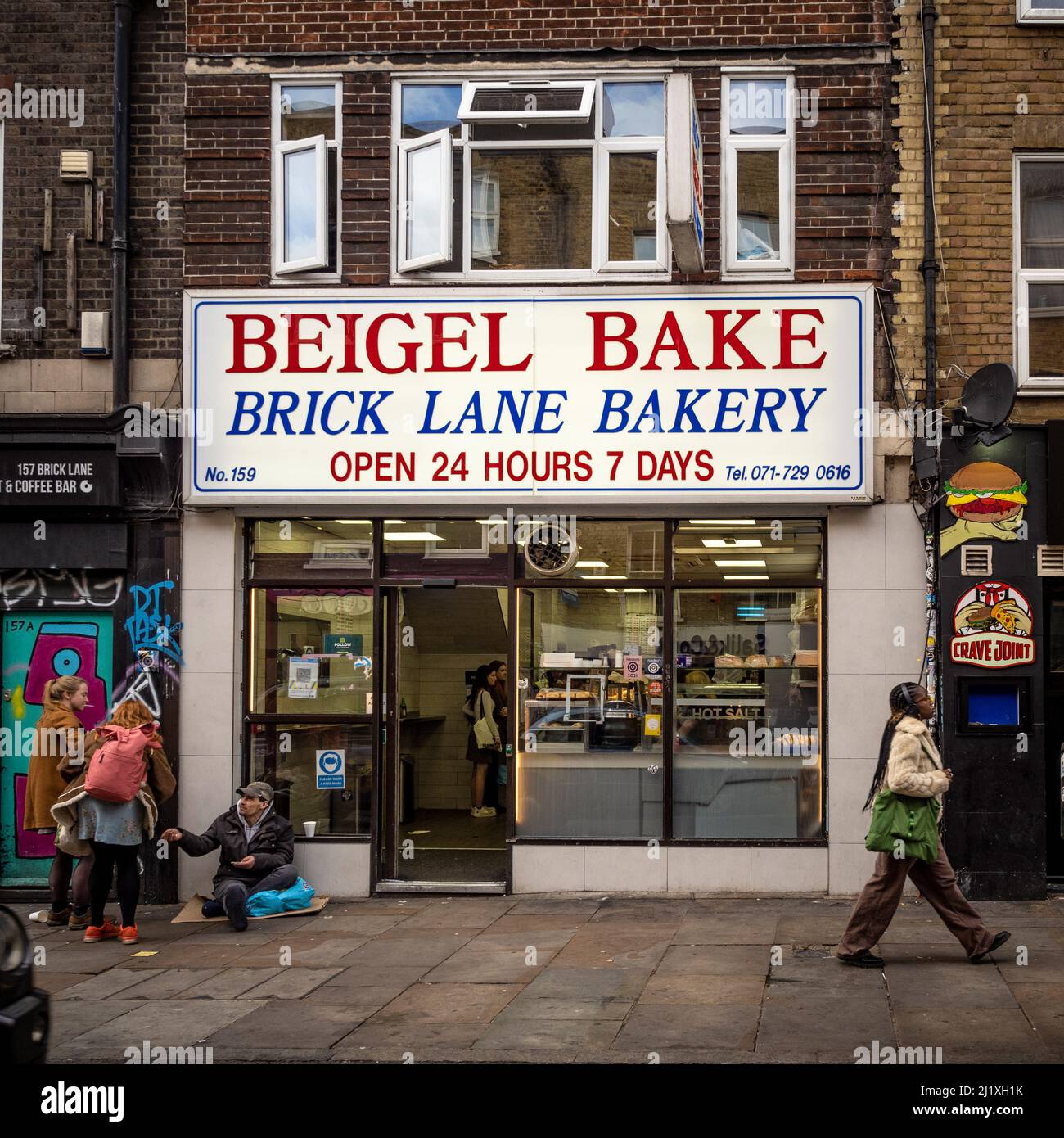 Homeless caucasian male sitting on the pavement outside a Brick Lane ...
