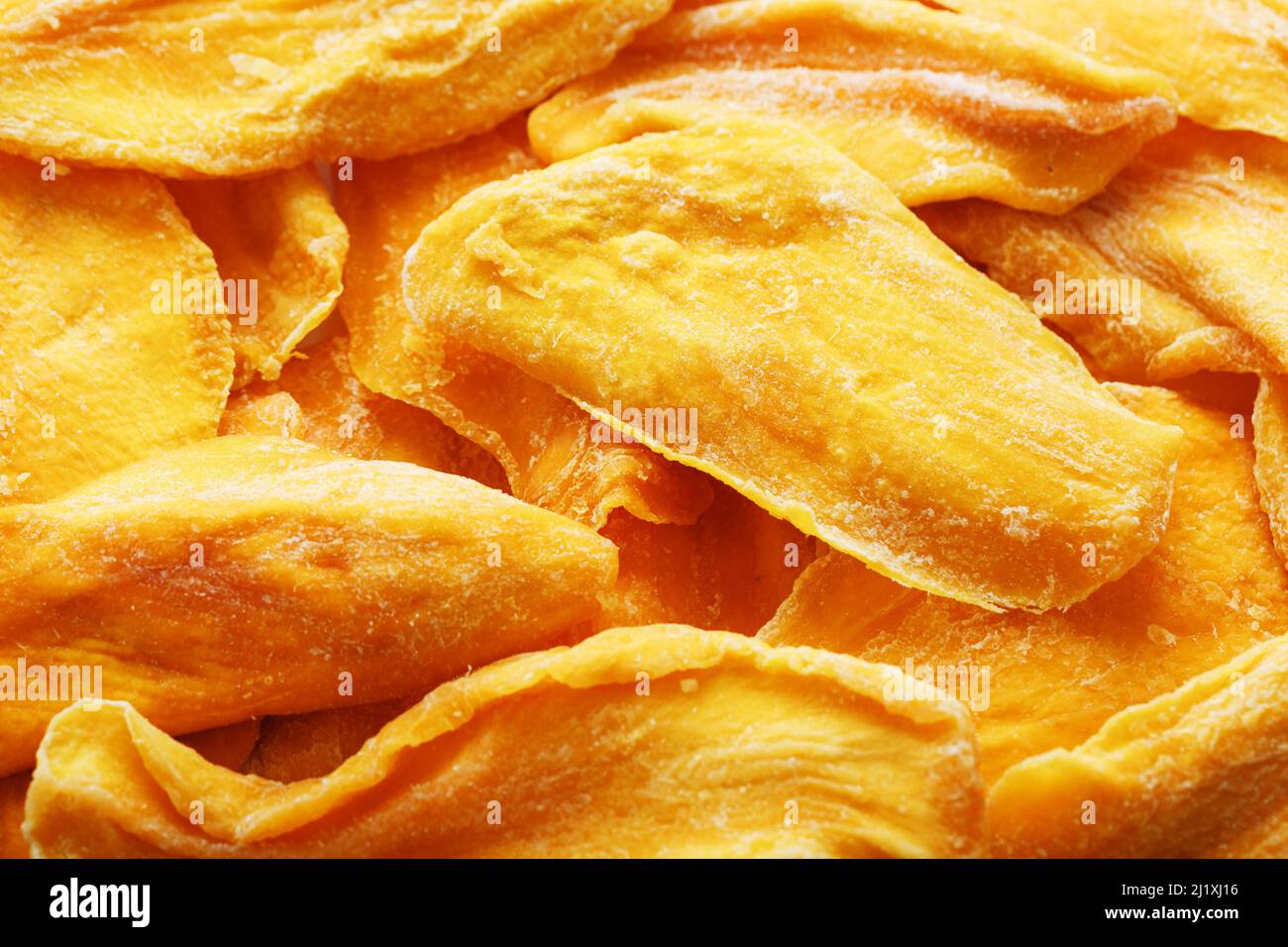 Pieces of sweet dried mango close-up as a background in full screen top ...