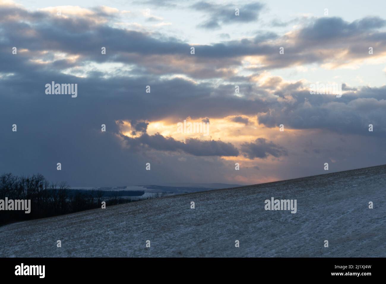 A beautiful sunset sky over a hillside field Stock Photo - Alamy