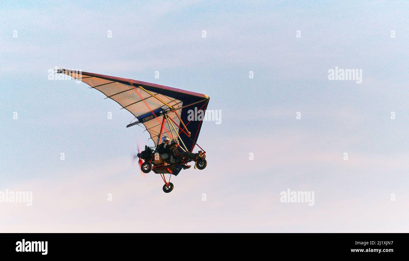 two people flying microlight in a summer sunset Stock Photo - Alamy