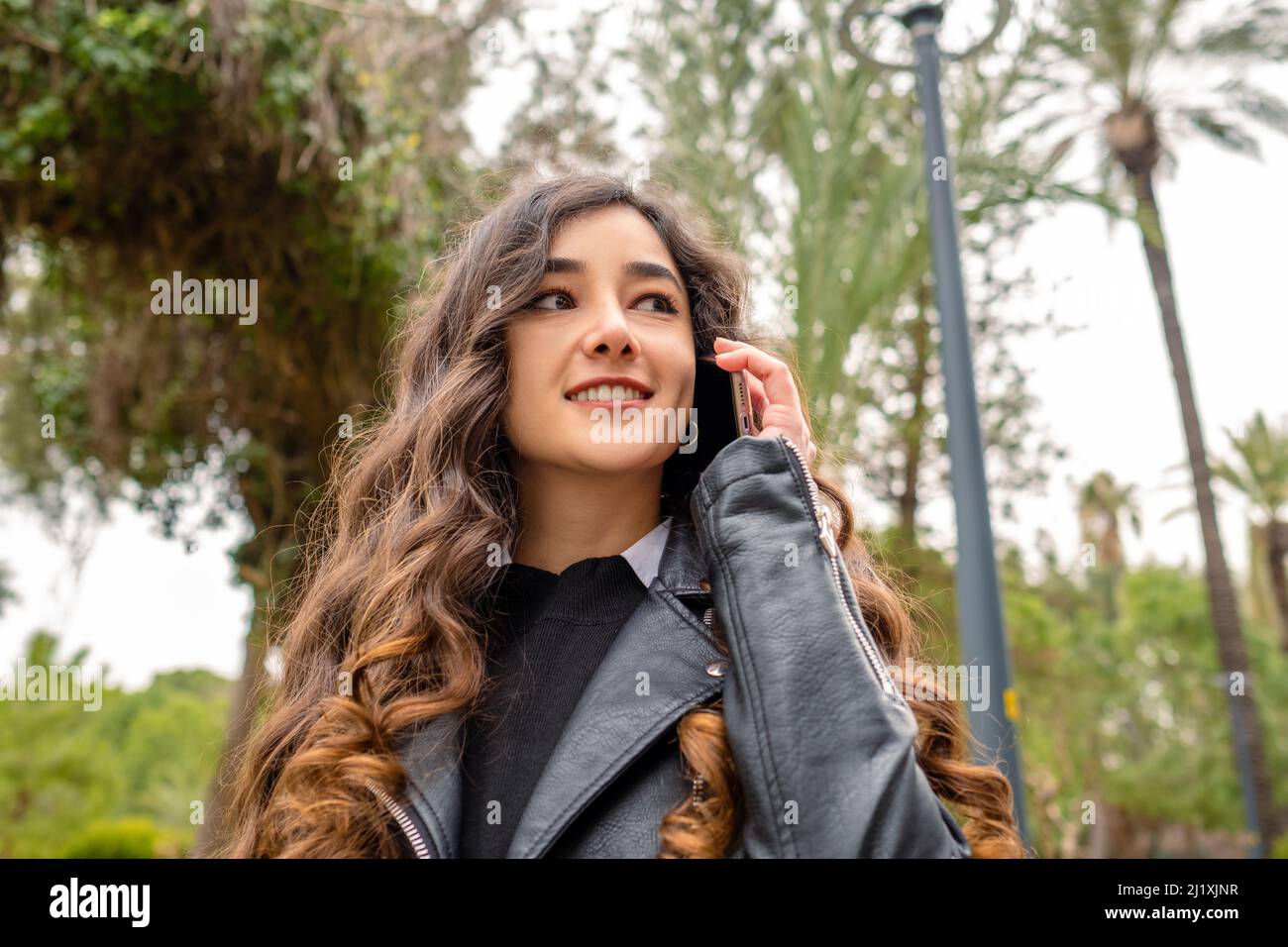 Young smiling woman talking on the phone, beautiful woman with wavy ...