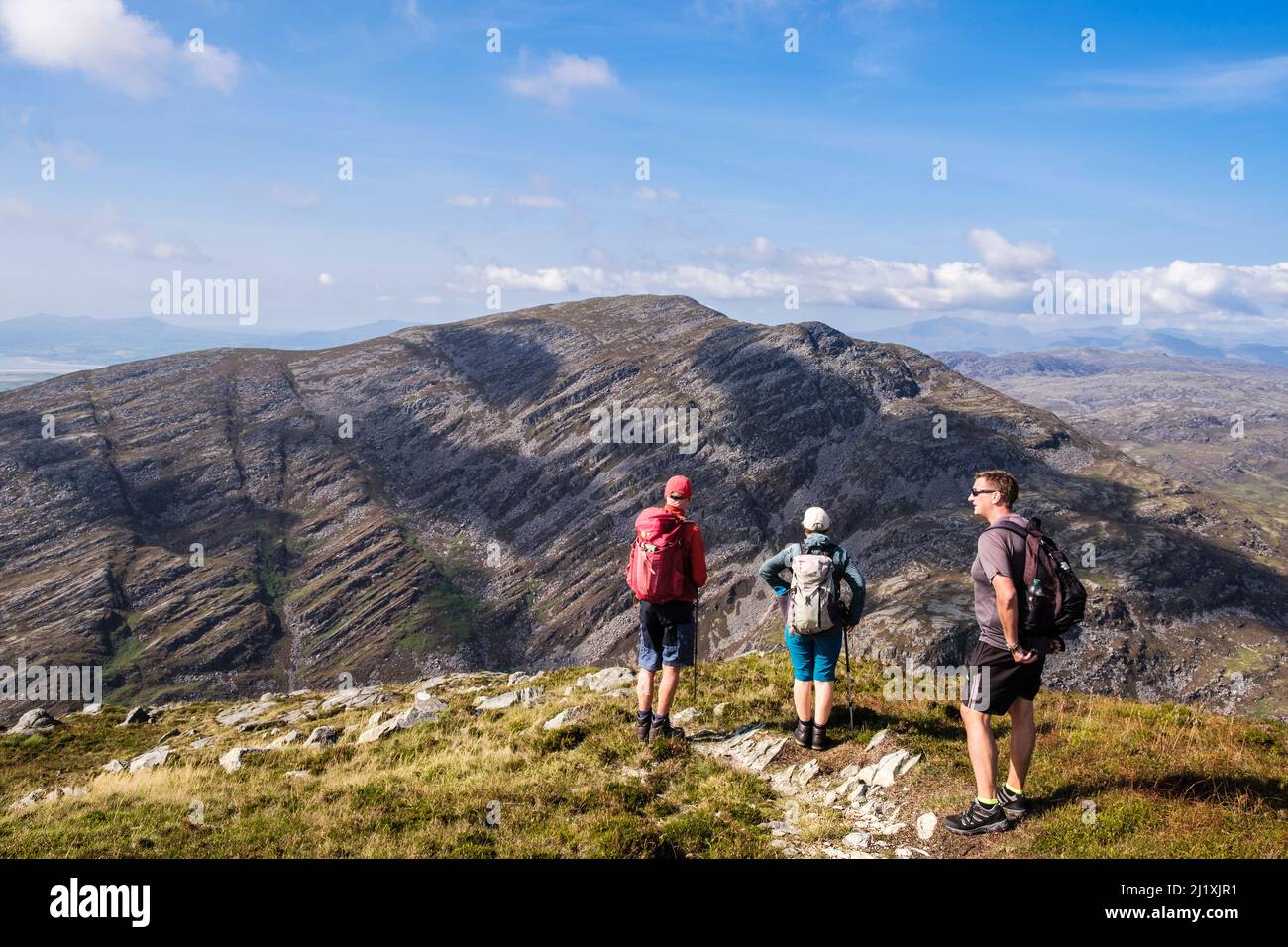 Hikers looking at Rhinog Fawr from Rhinog Fach in the Rhinogs range in ...