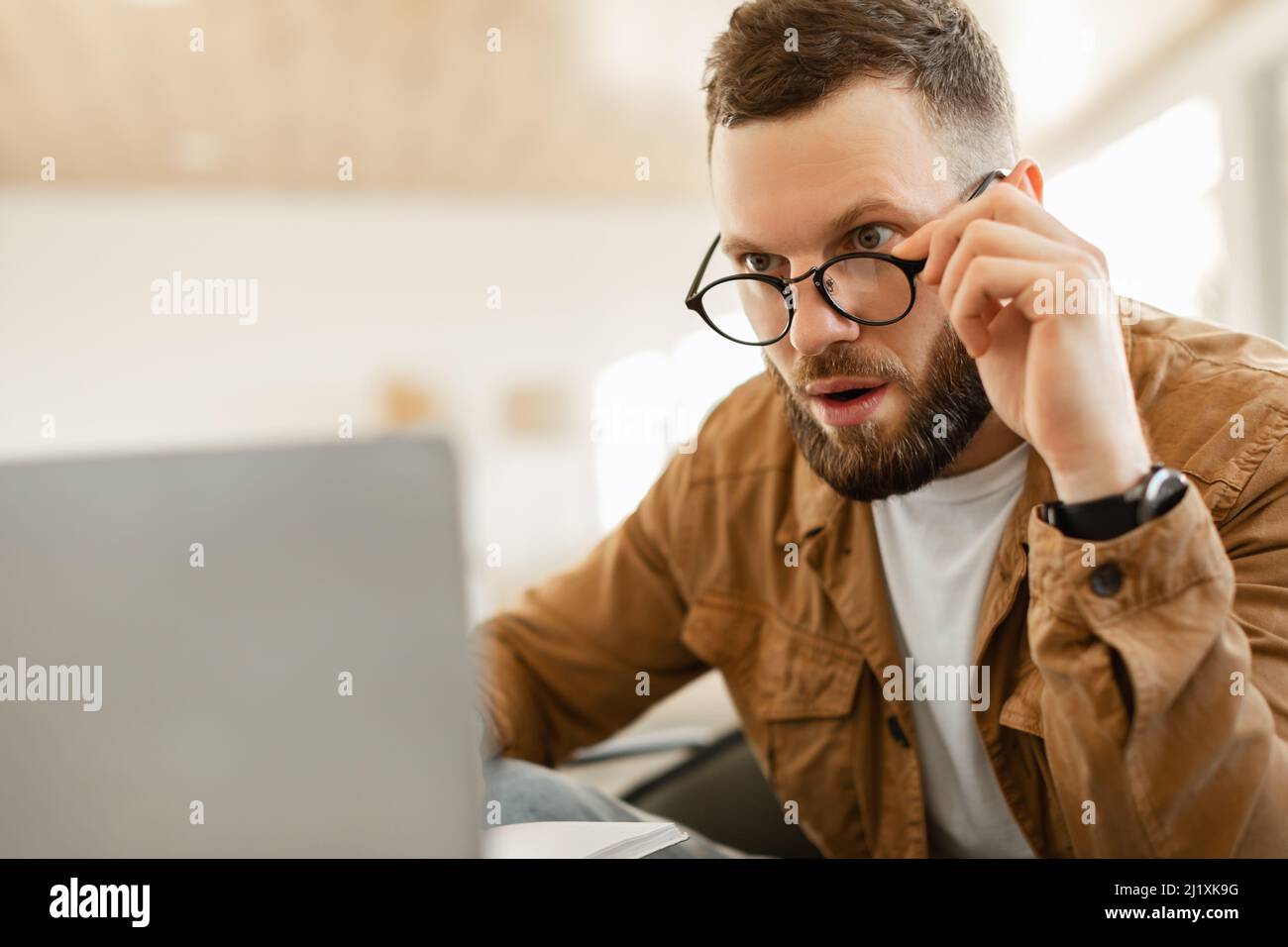 Man Looking At Laptop Screen In Shock Above Glasses Indoor Stock Photo ...