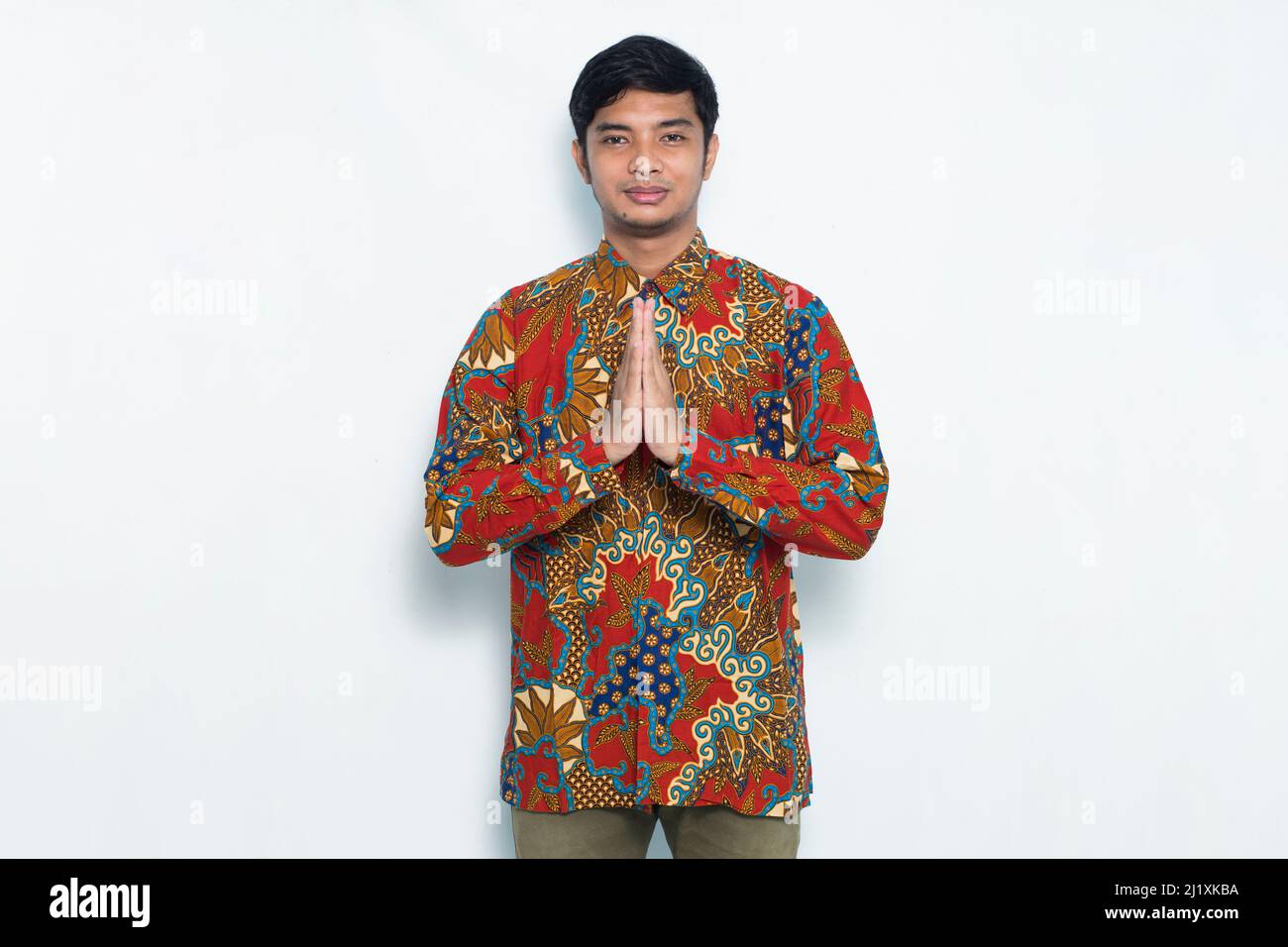 portrait of young javanese man wearing batik showing welcome hand ...
