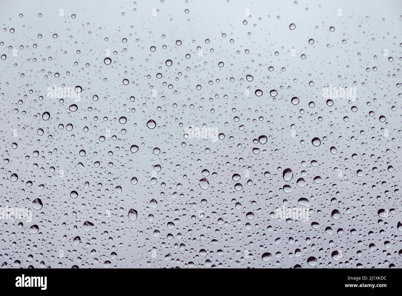 Raindrops on a window with rivulets of water runnng down the pane Stock Photo - Alamy