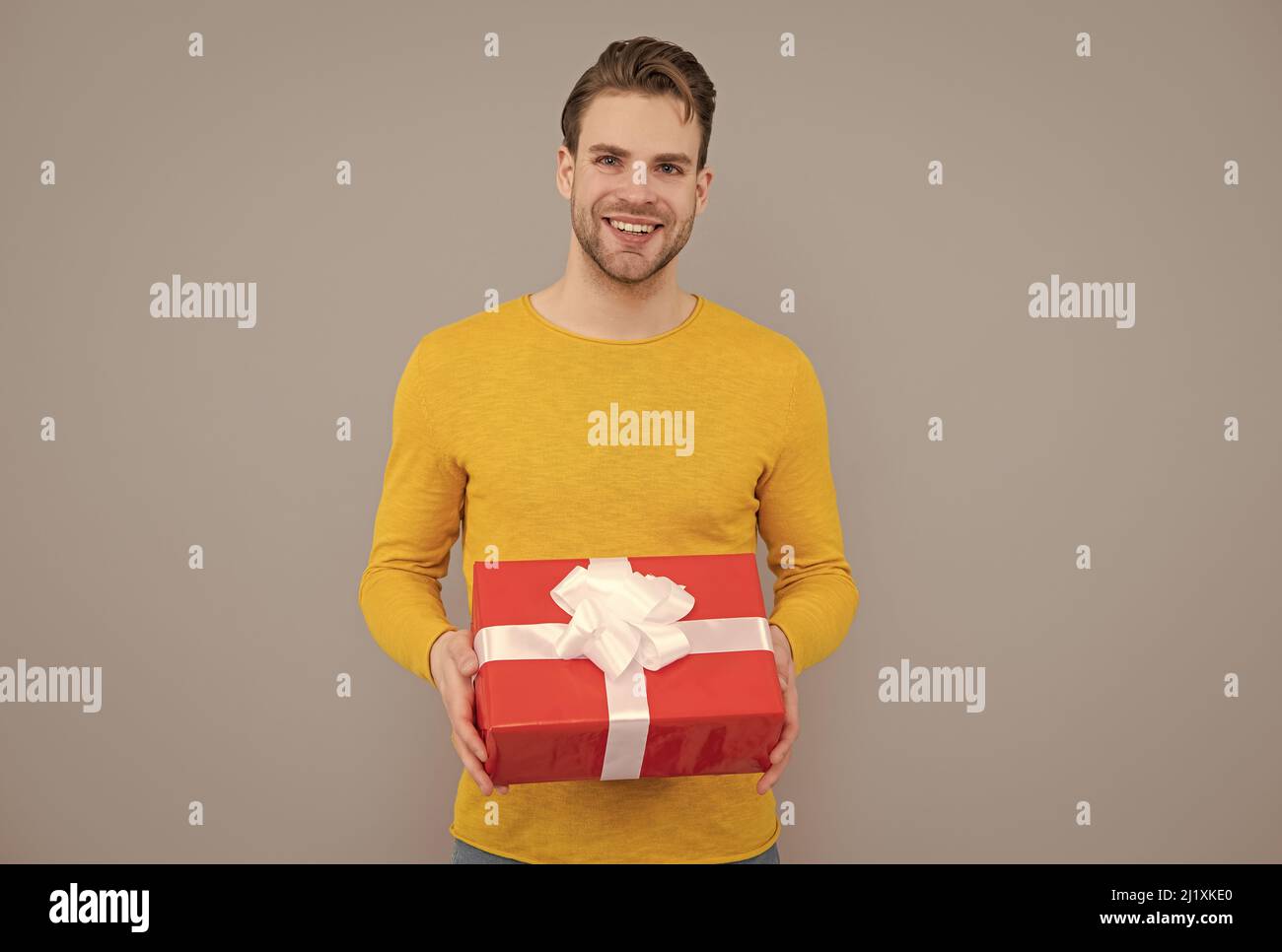 Making present. Happy guy hold present box Stock Photo - Alamy