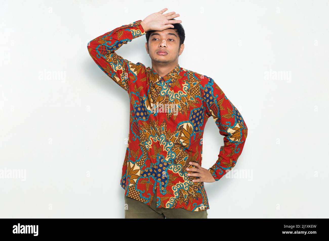 Young javanese man wearing batik feeling tired isolated on white ...