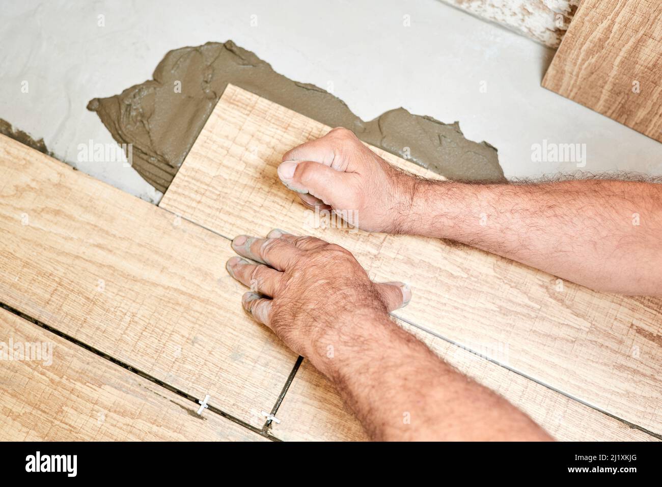 Man laying ceramic floor tiles. Close-up, selective focus Stock Photo ...