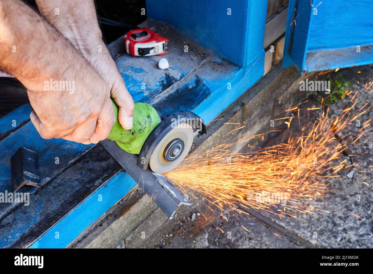 Cutting a metal corner with a circular saw with splashes of sparks ...
