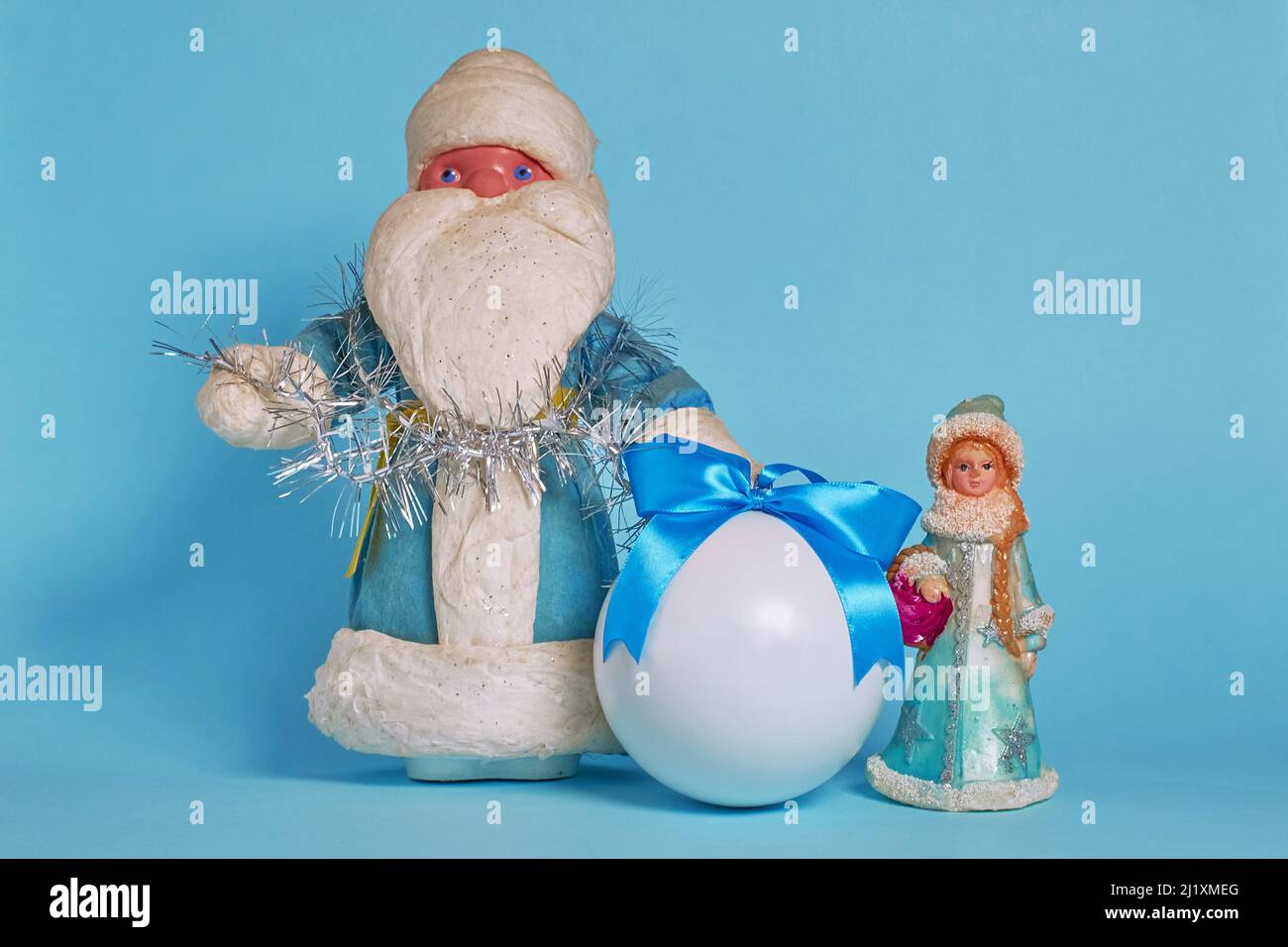 A toy Russian Snow Maiden and Ded Moroz holding a Christmas ball Stock ...