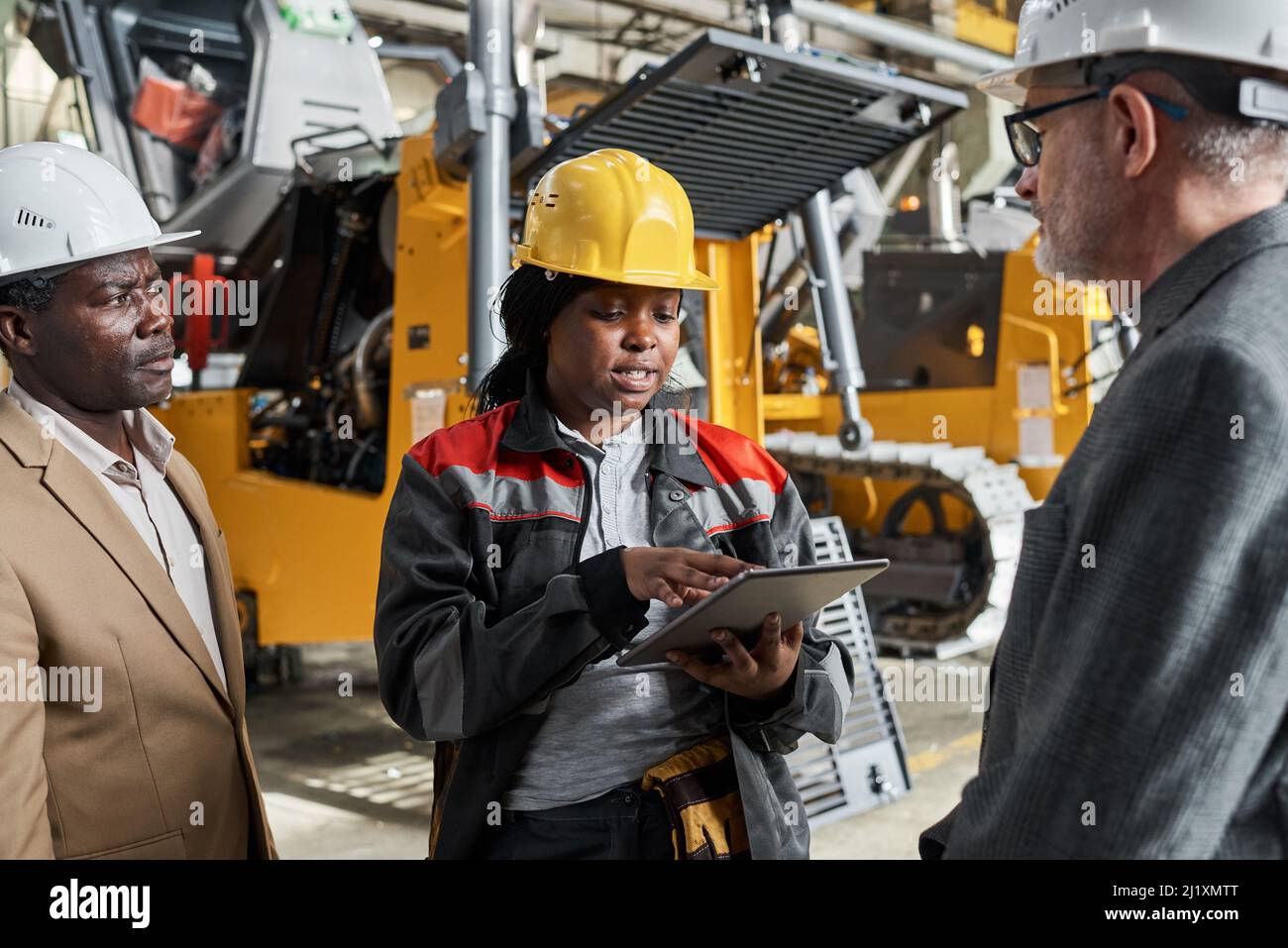 African female worker in uniform using tablet pc and presenting her ...