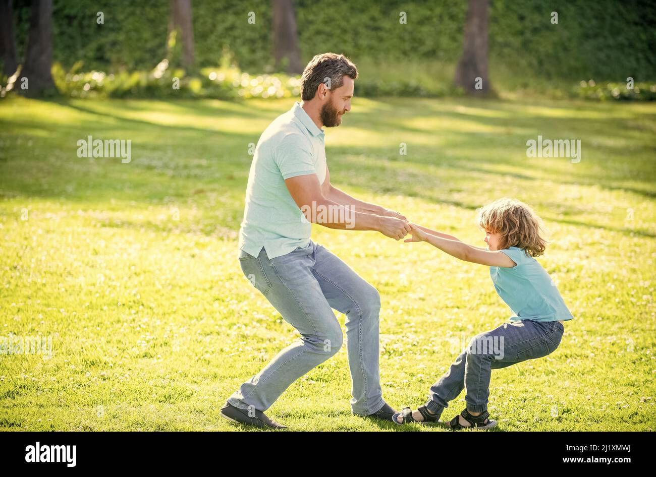 Happy boy child pull fathers hands playing on summer outdoors, play ...