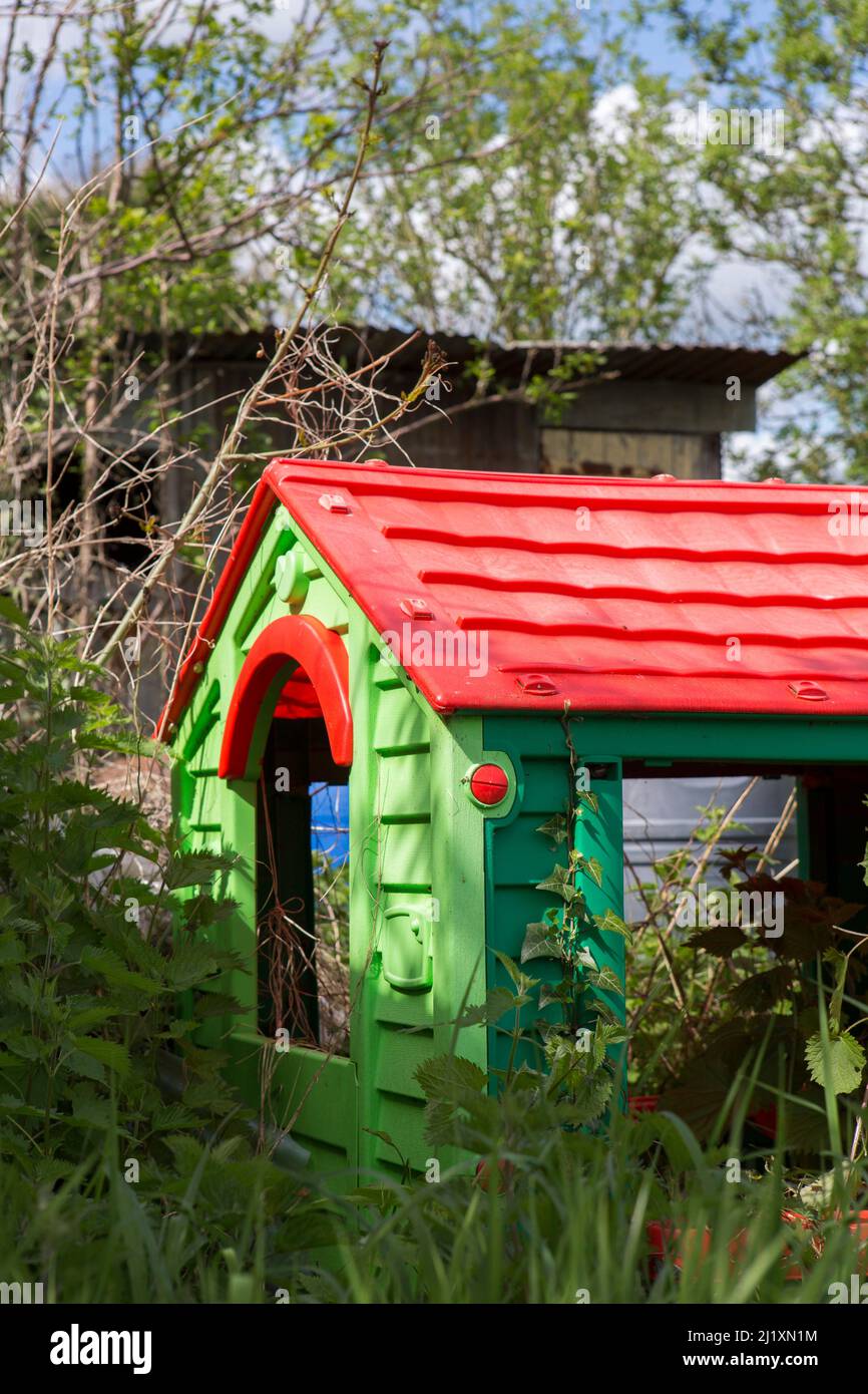 Tiny plastic childs play house on an allotment with red plastic roof ...