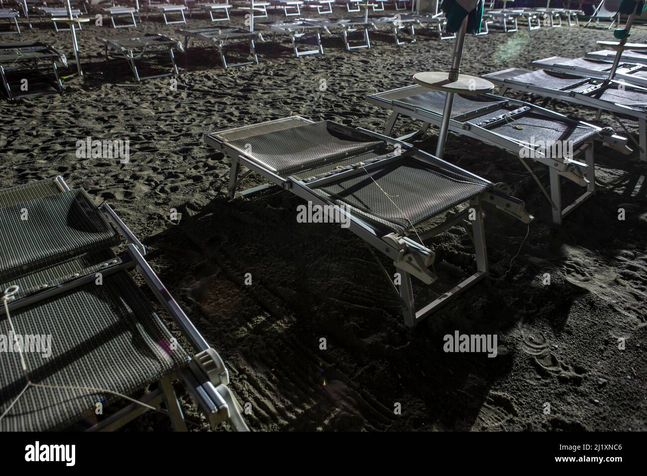 Beach umbrellas, sun loungers and chairs on an italian beach at sunset ...