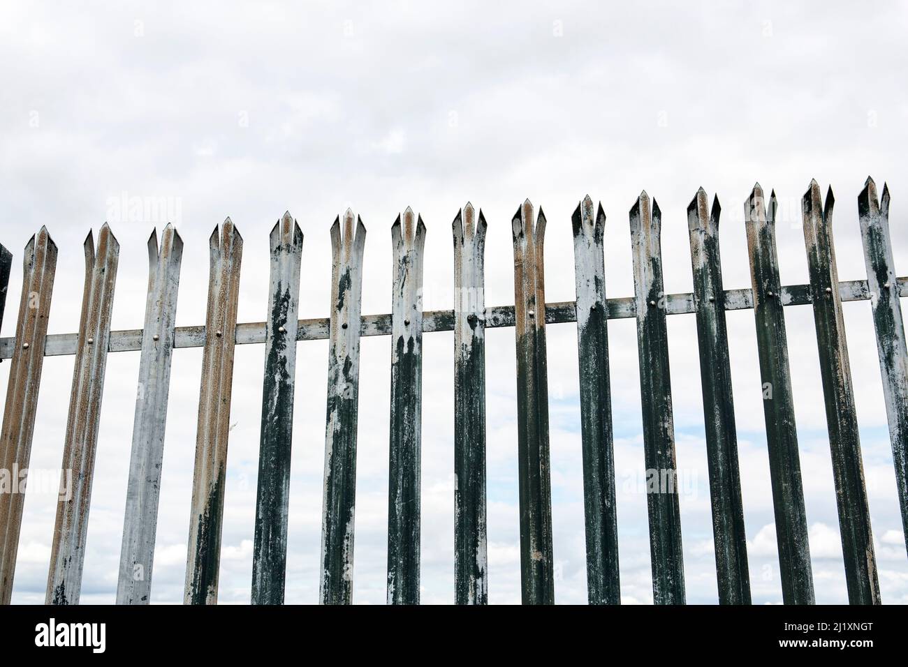 A high security fence with sharp metal spikes on the top set up to ...