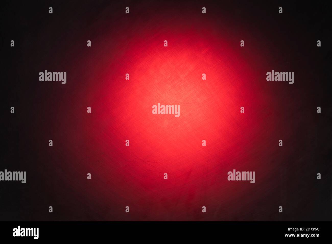 Red grunge background with a dark vignette and a light spot in the ...