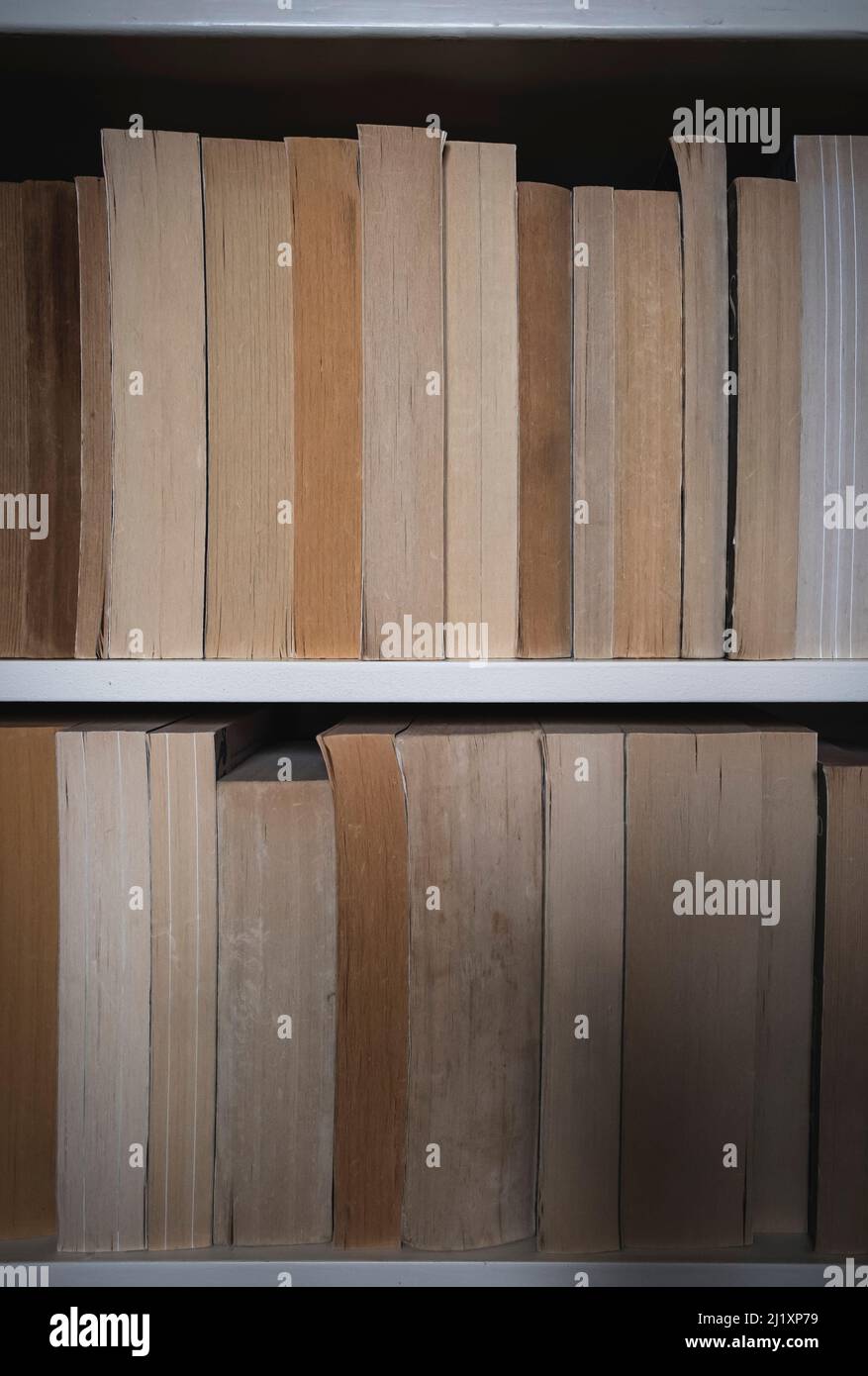 Shelves of paperback books turned inwards so the spine cannot be seen ...