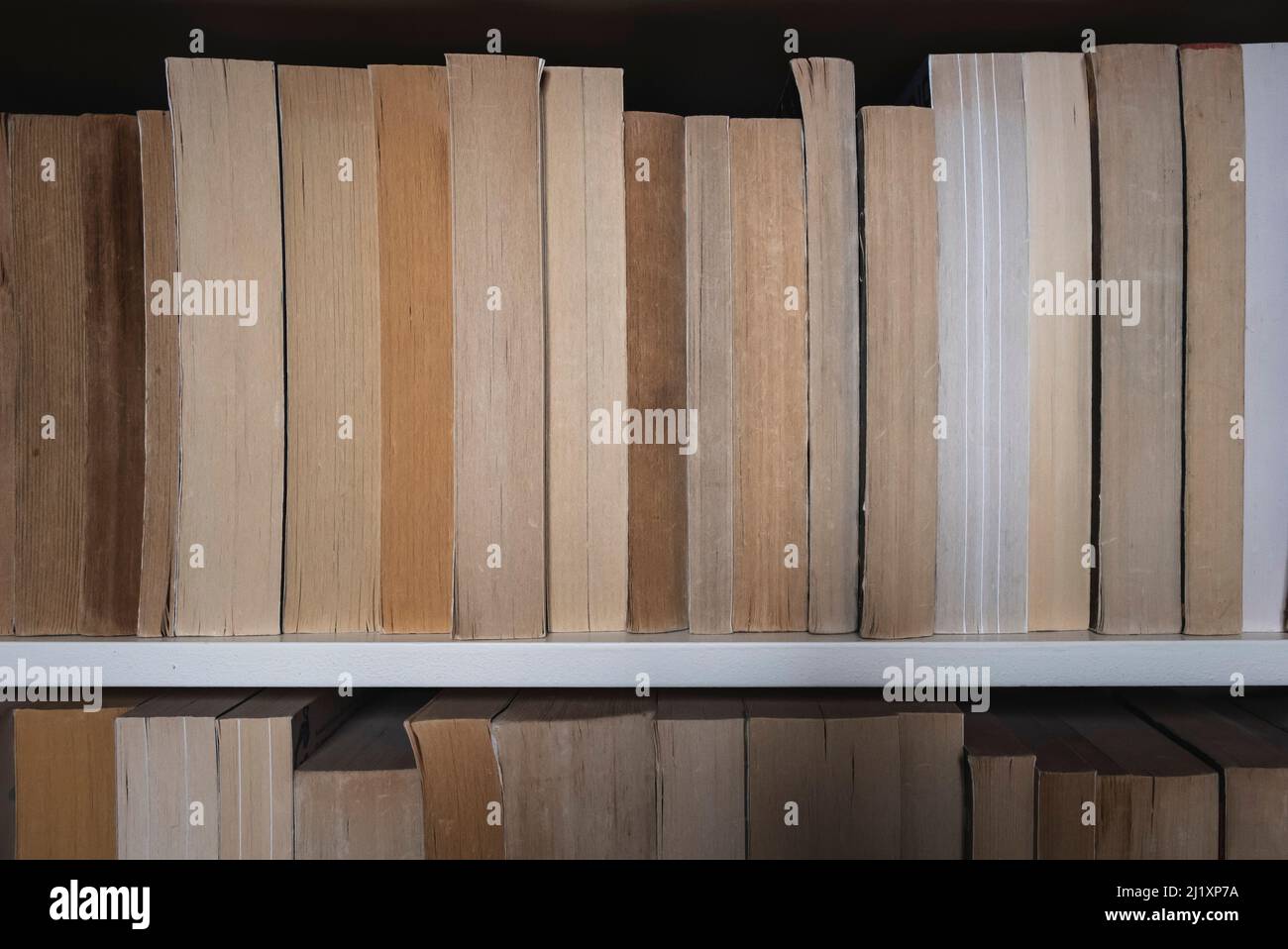 Shelves of paperback books turned inwards so the spine cannot be seen ...