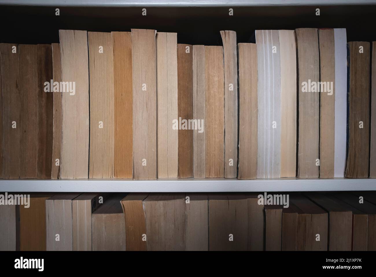 Shelves of paperback books turned inwards so the spine cannot be seen ...