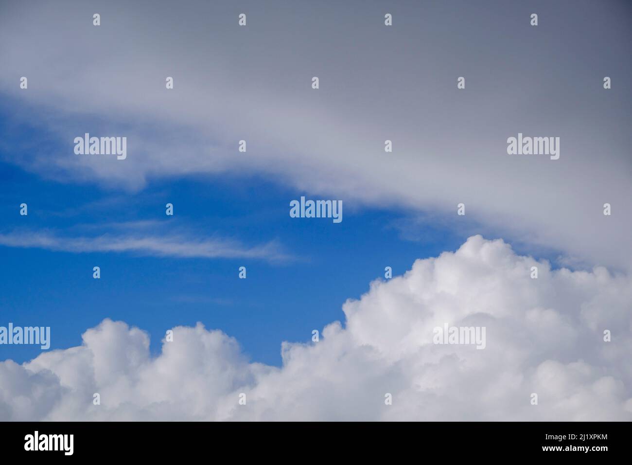 Large clouds on a strom front rolling in across ablue sky blocking the ...