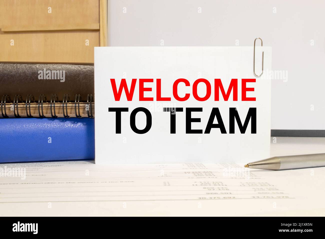 Businesspeople holding whiteboard with 'welcome to the team' text ...