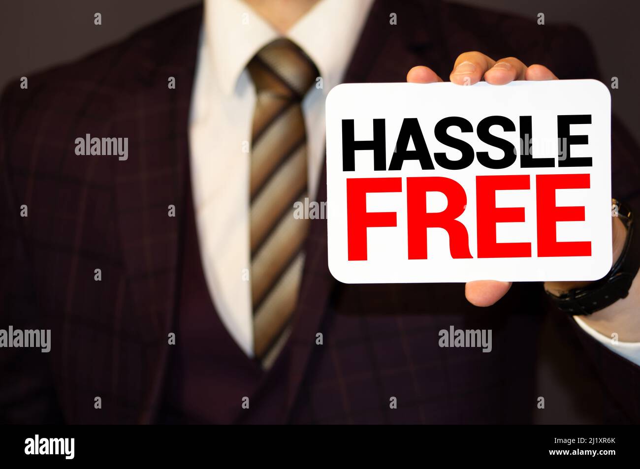 The words Hassle Free in red text on a note card pinned to a cork ...