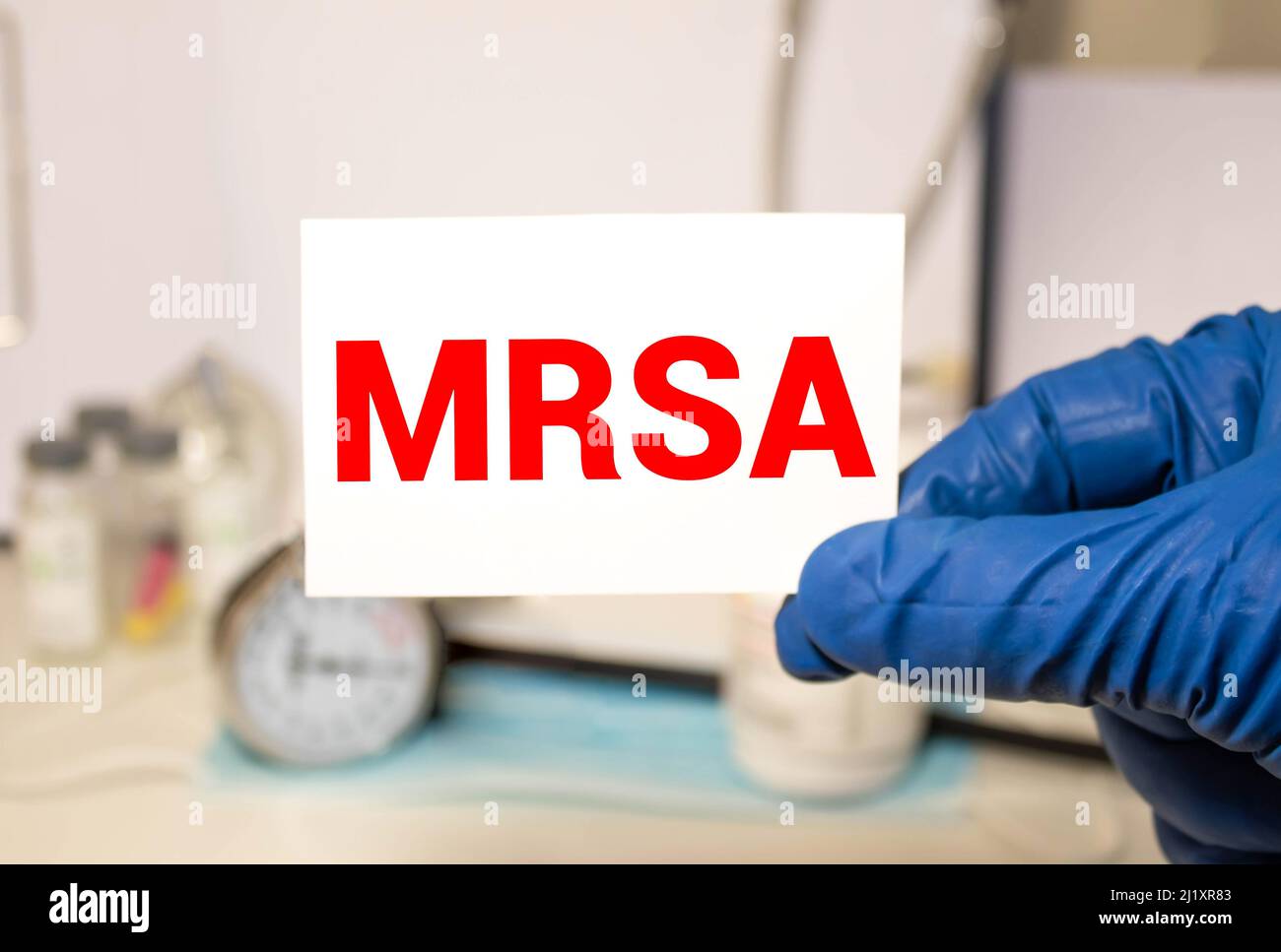 Doctor's hands in blue gloves shows the word MRSA methicillin-resistant ...