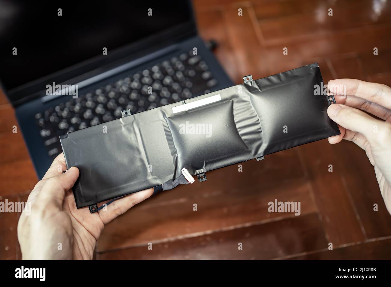 Swollen laptop battery in hands Stock Photo - Alamy