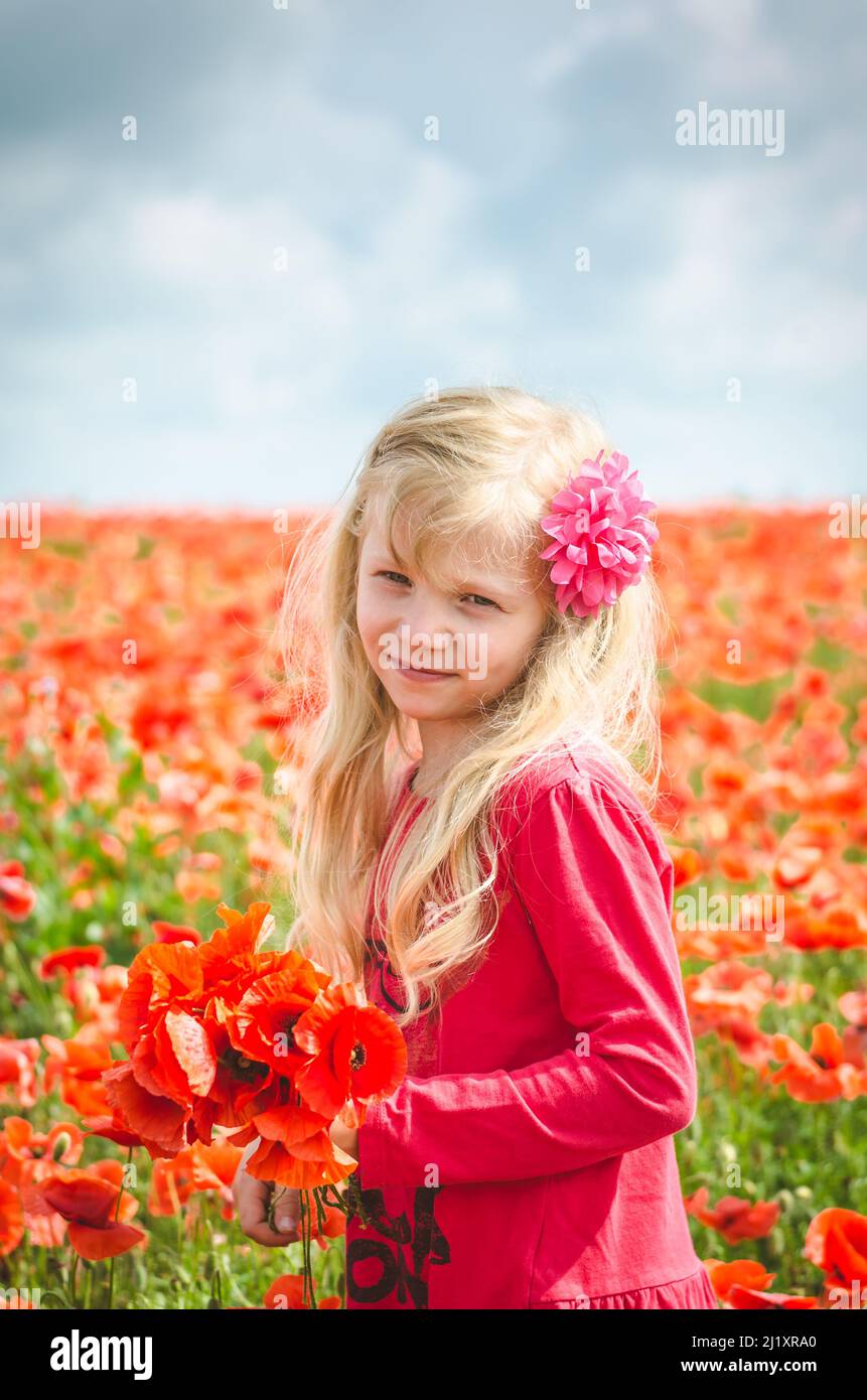 lovely little girl with red poppies in hand Stock Photo - Alamy