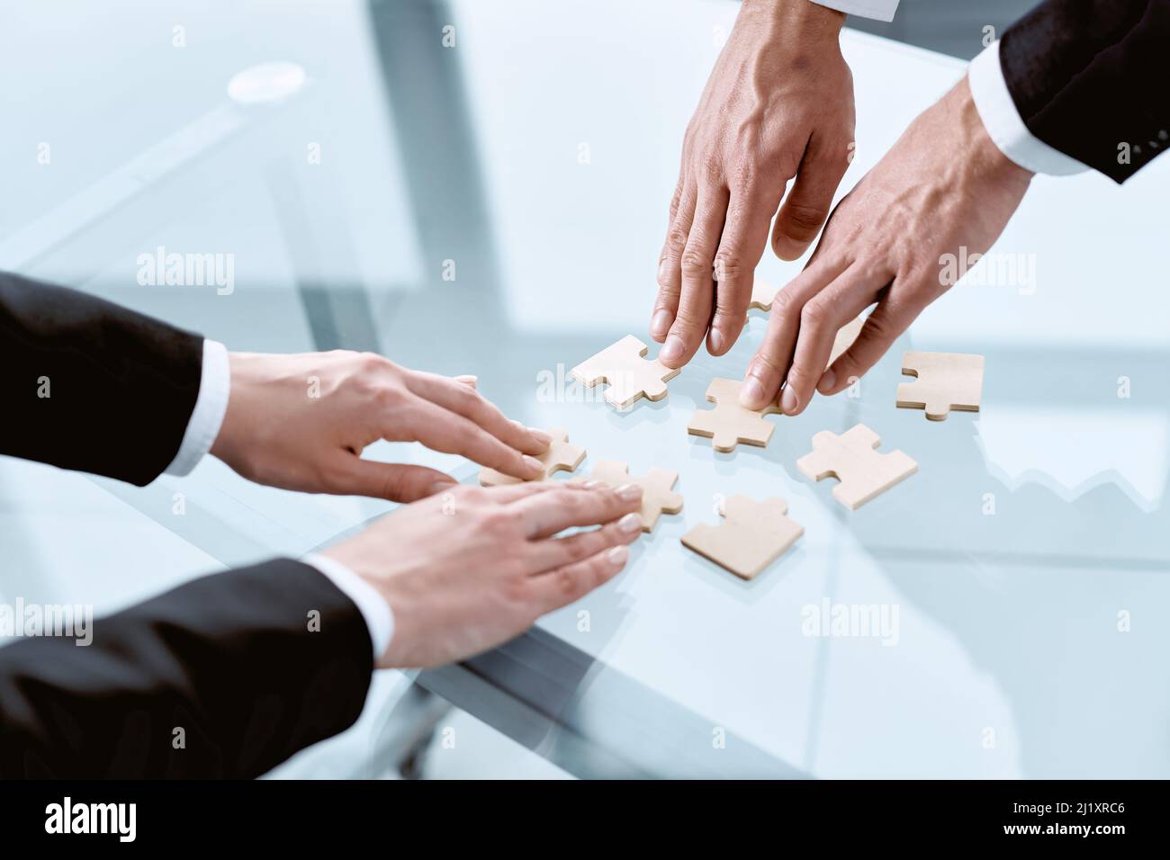 business partners putting together the pieces of the puzzle Stock Photo ...