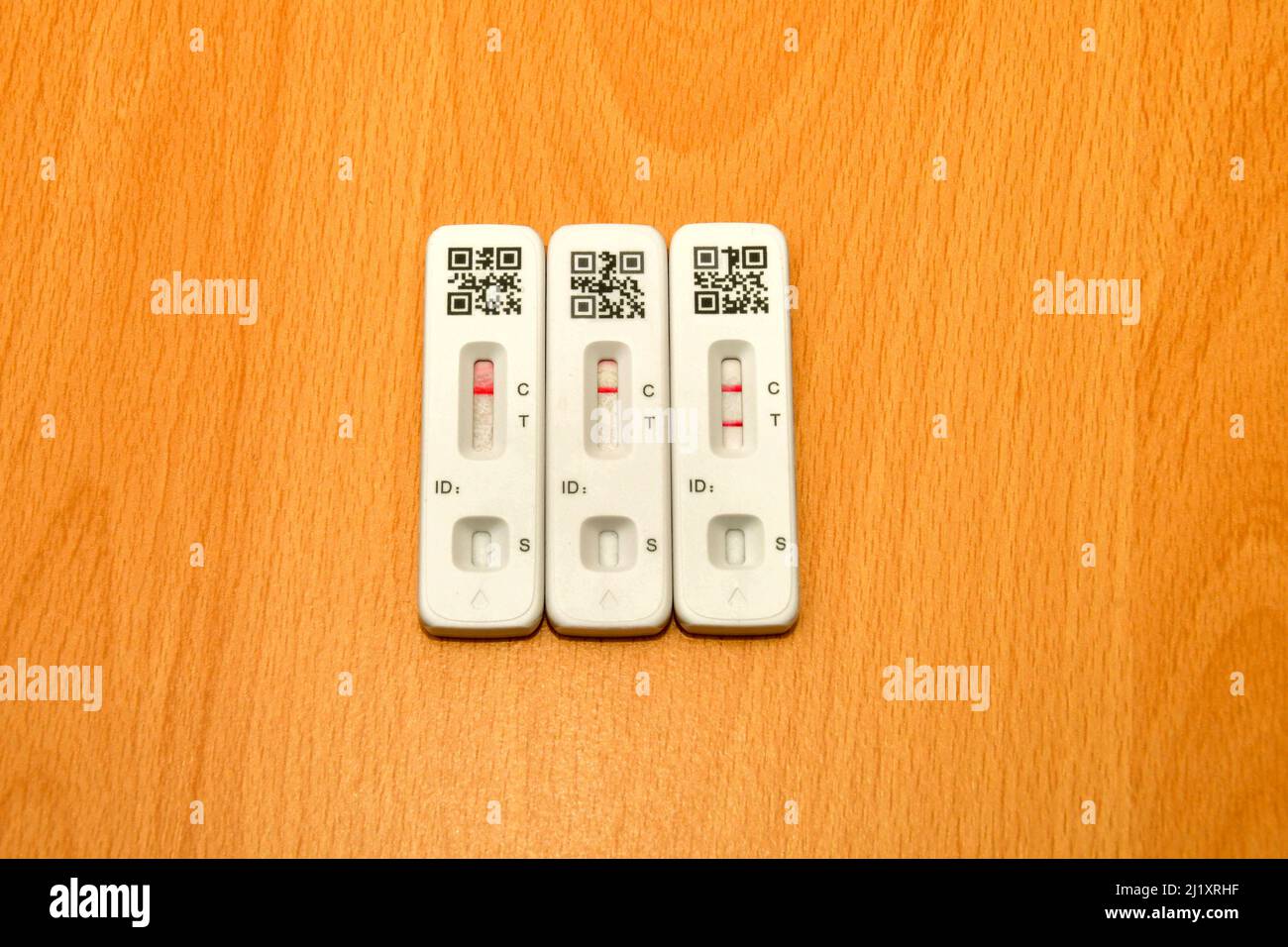 Two negative lateral flow tests with a positive test on the right, all ...