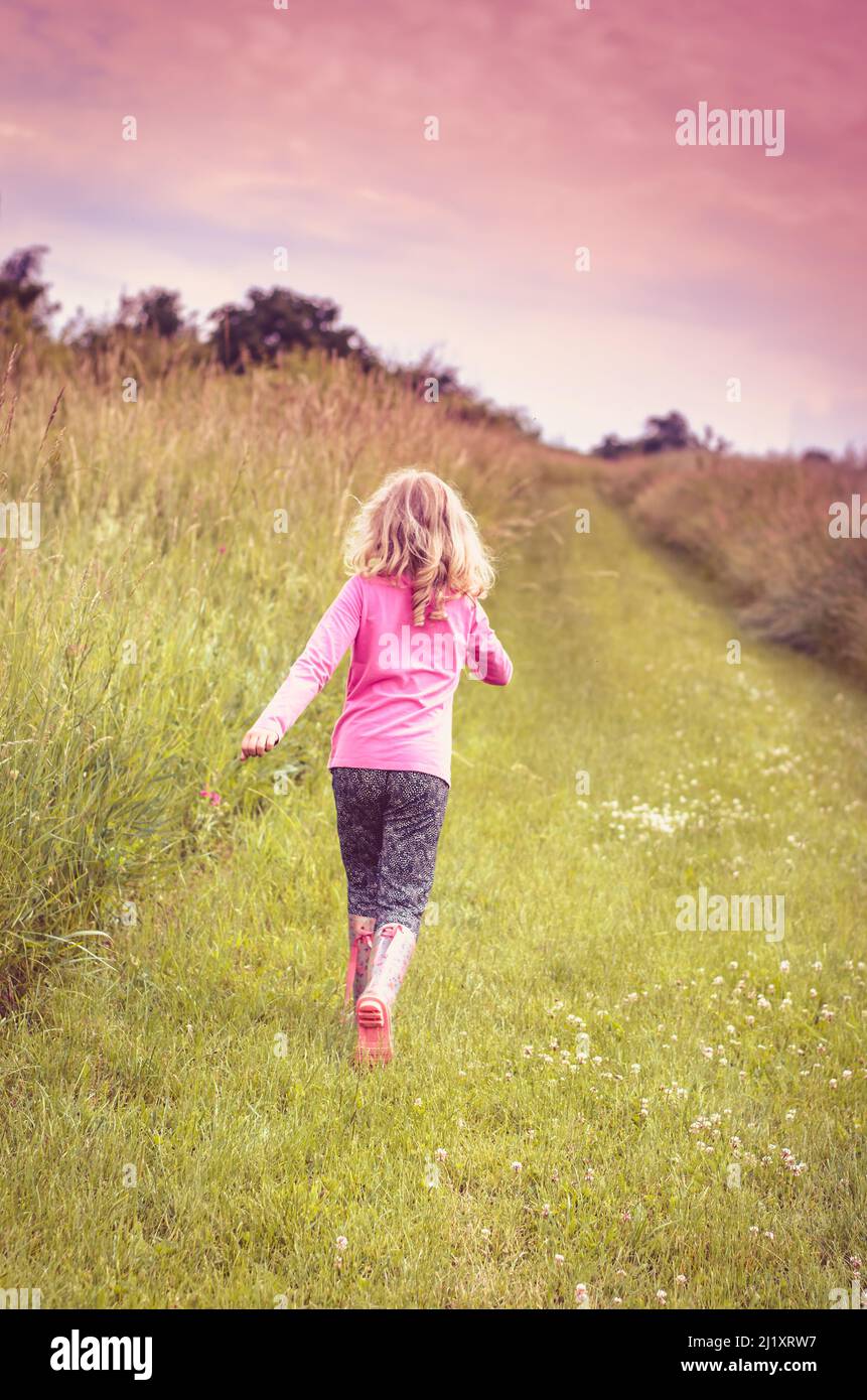 girl with long blond hair back view walking in rural path Stock Photo ...