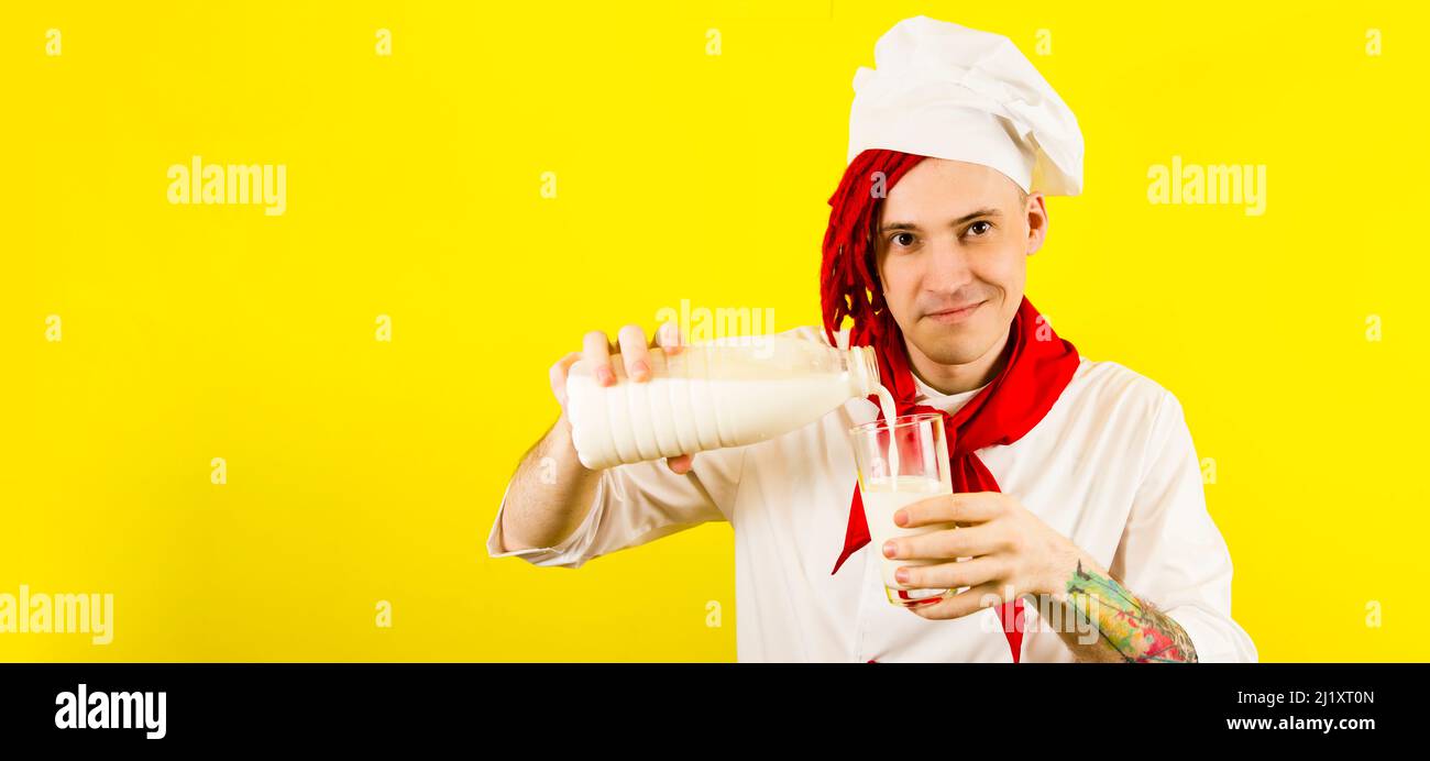 Man with red dreadlocks with bottle milk. Confident young cook in white ...