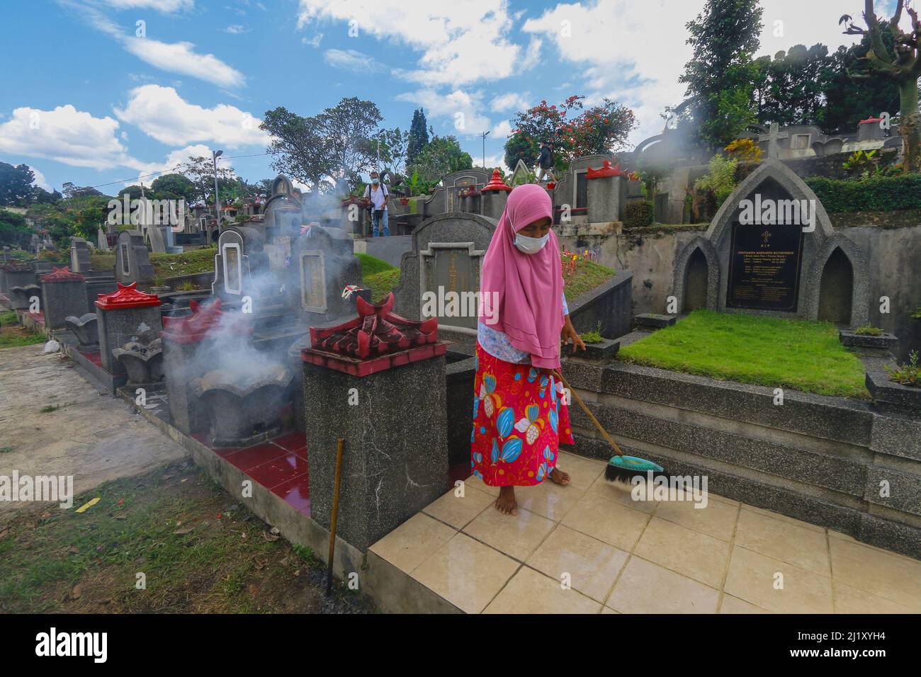 A worker sweeps a Chinese cemetery during the Cheng Beng or Qingming ...