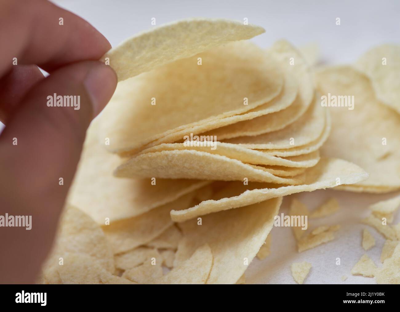 Close-up view of a hand picking potato chips Stock Photo - Alamy