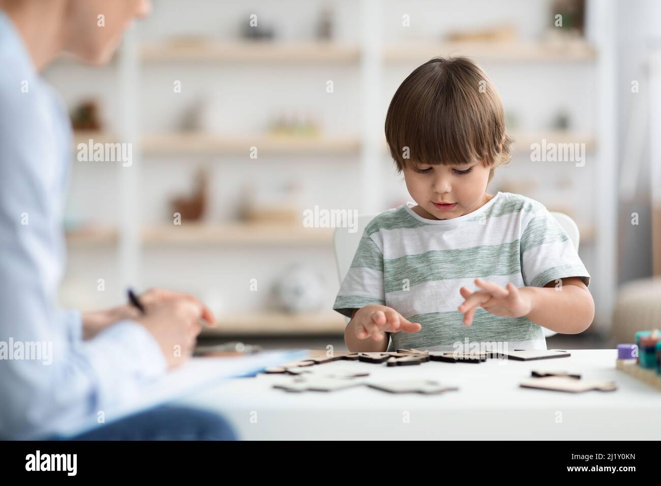 Cute little boy exercising with professional kids tutor at preschool ...