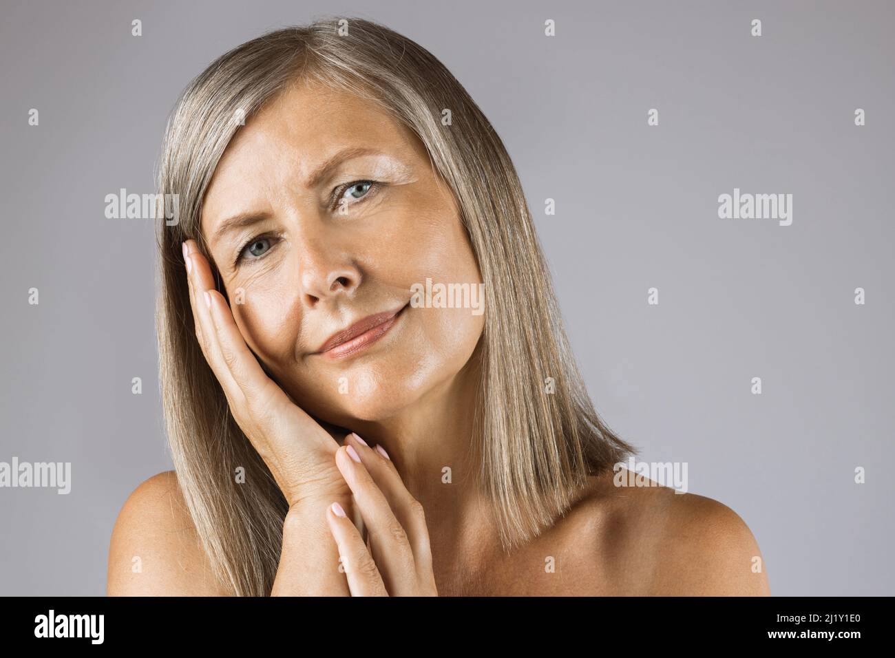 Pleasant caucasian lady looking at camera with natural wrinkles around ...