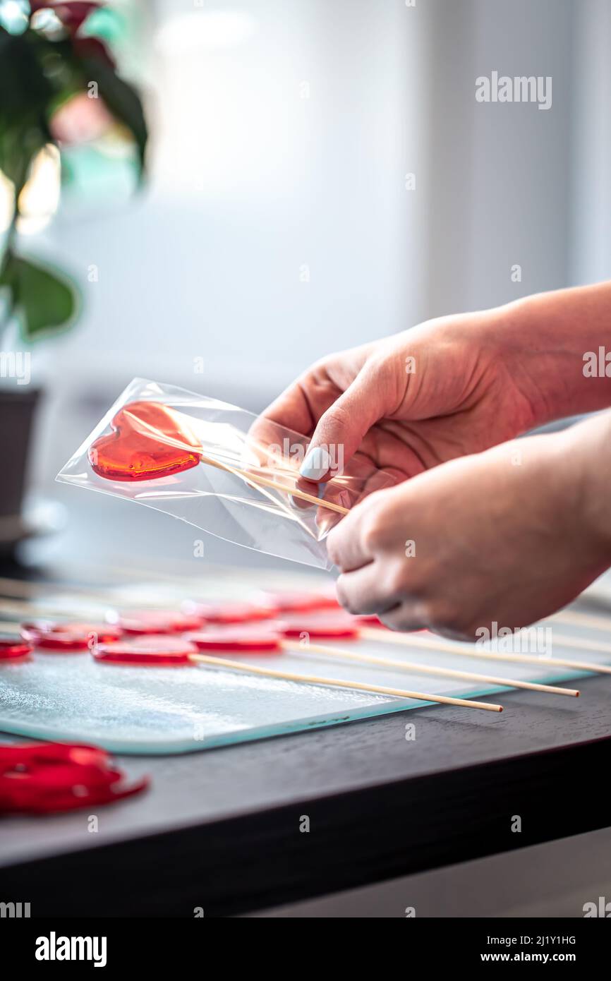 Packaging of red lollipops in the shape of hearts Stock Photo - Alamy