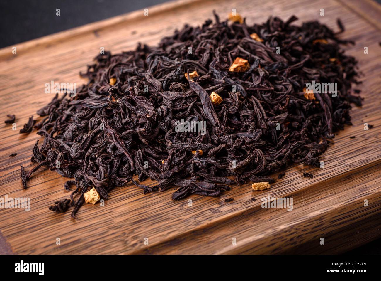 Black large-leaf tea as a background. Texture of dry black tea leaves ...
