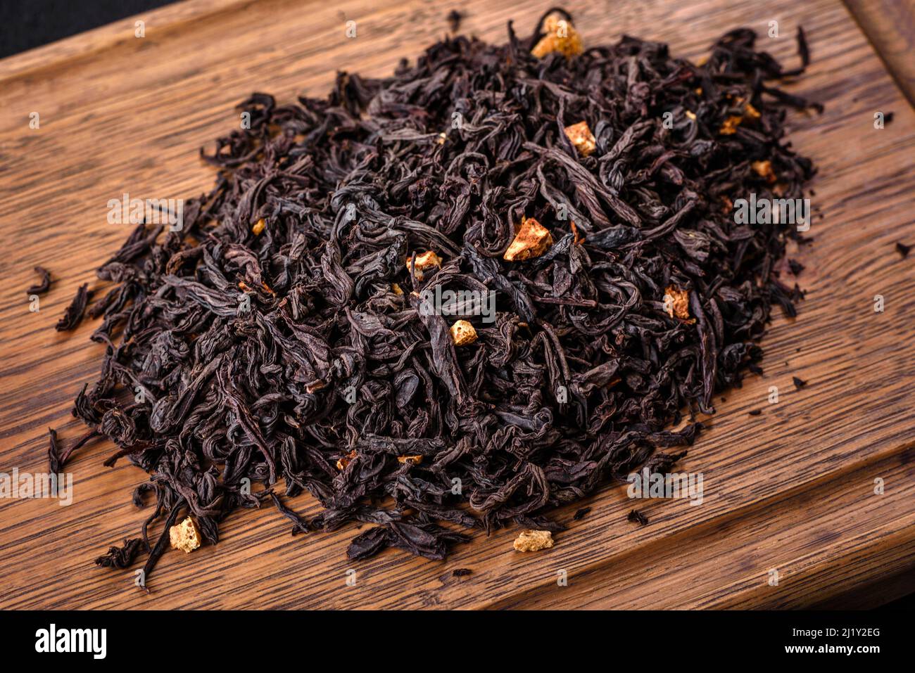 Black large-leaf tea as a background. Texture of dry black tea leaves ...