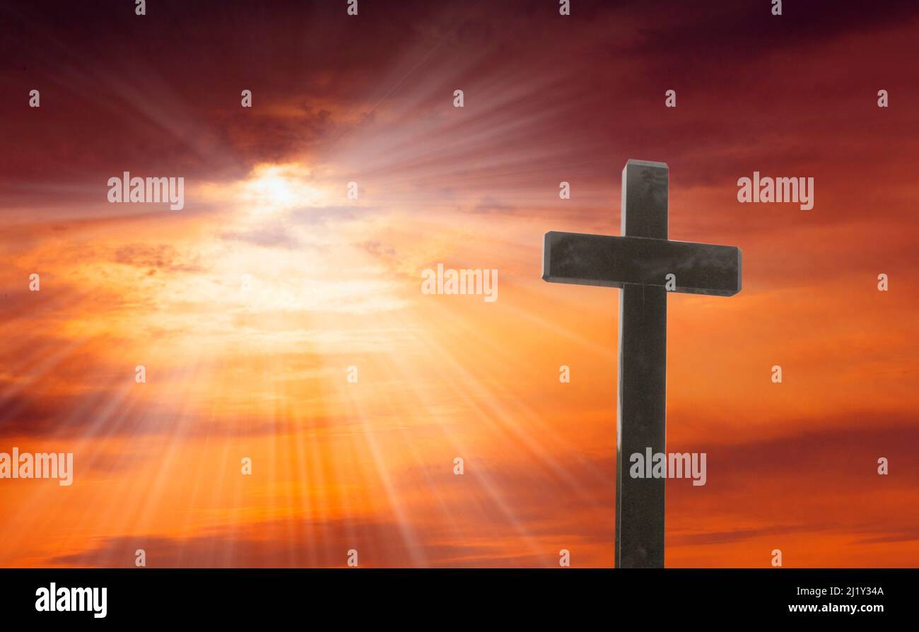 Wooden cross stand against a dramatic evening sky with radiant beams ...